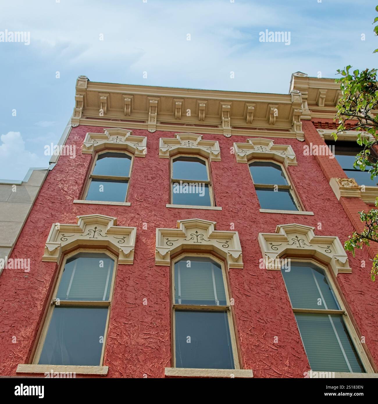 Ornate facade on brick building with Italianate window pediments Stock ...