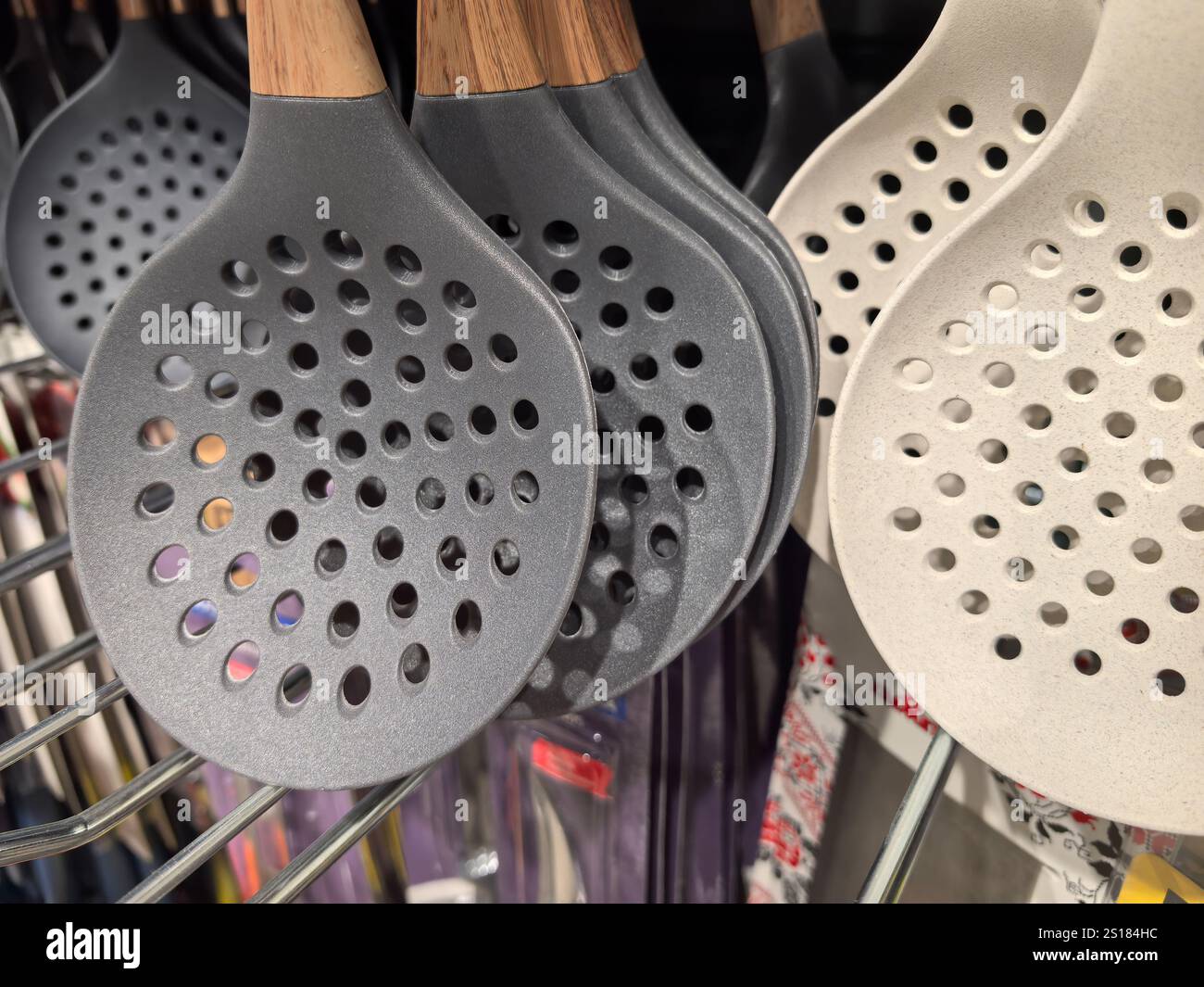 A collection of beautifully crafted kitchen utensils hangs in an ...