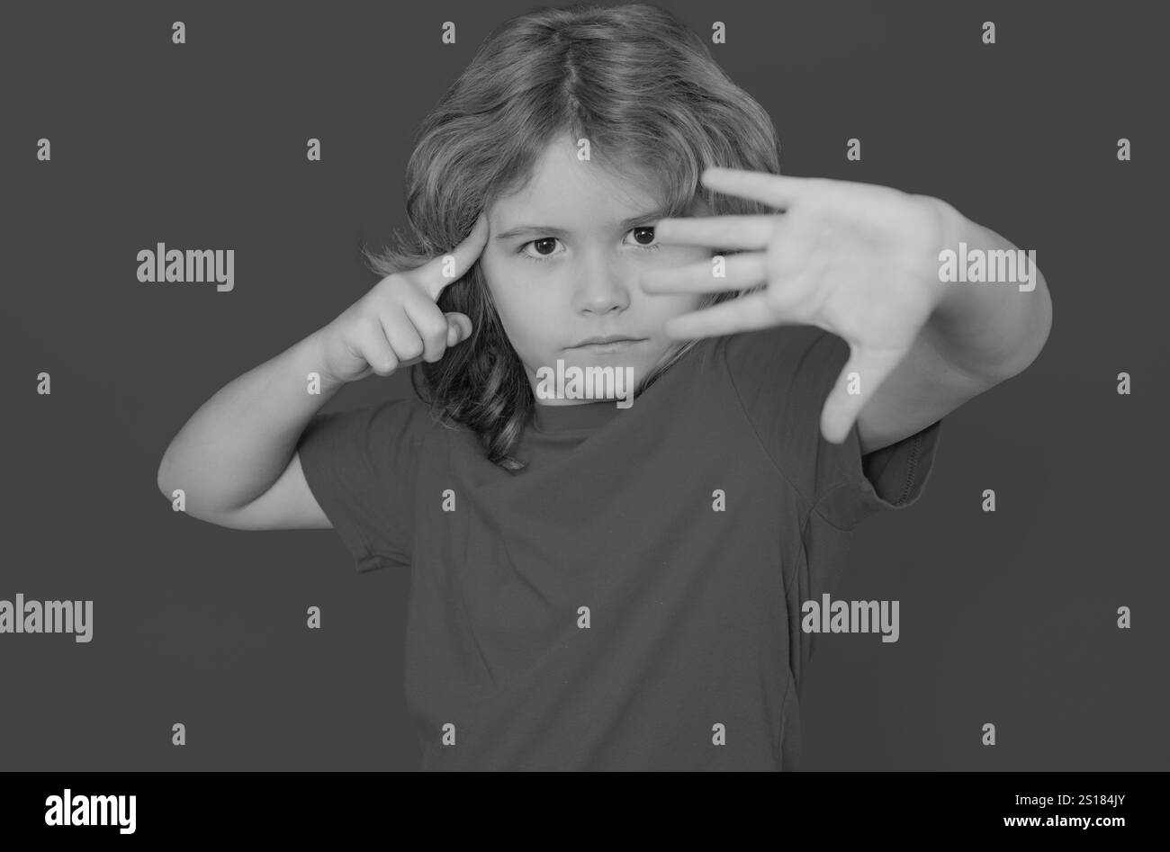 Child in red t-shirt making stop gesture on isolated studio background ...