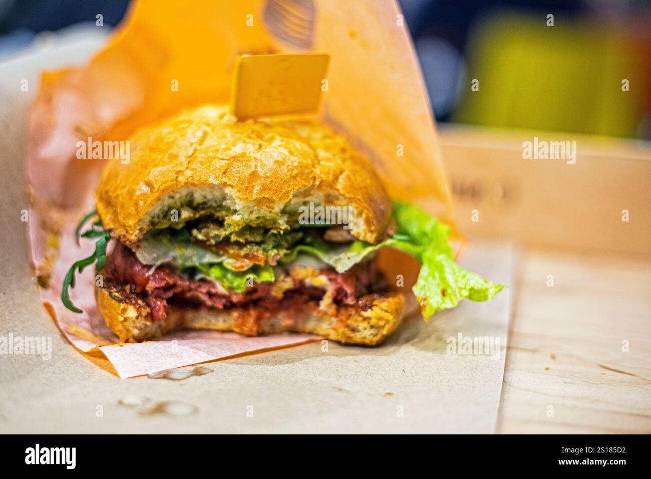 bitten hamburger with cheese, lettuce, pickle and vegetarian cutlet on ...