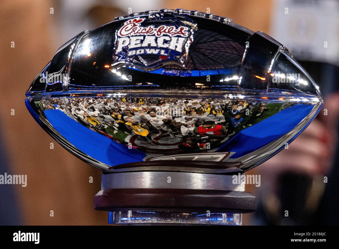 January 1, 2025: Texas crowds around the Peach Bowl trophy after ...