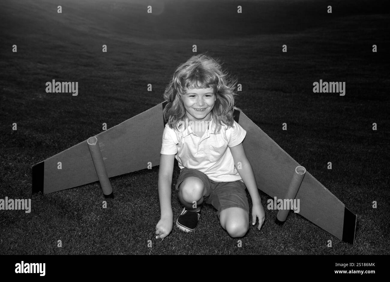 Child flying in plane made craft of cardboard wings. Dream, imagination ...