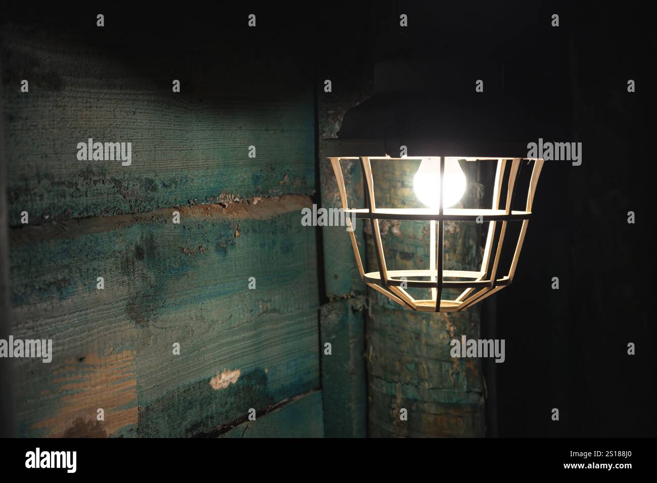 A vintage mine shaft lamp hangs in an underground tunnel, casting a ...