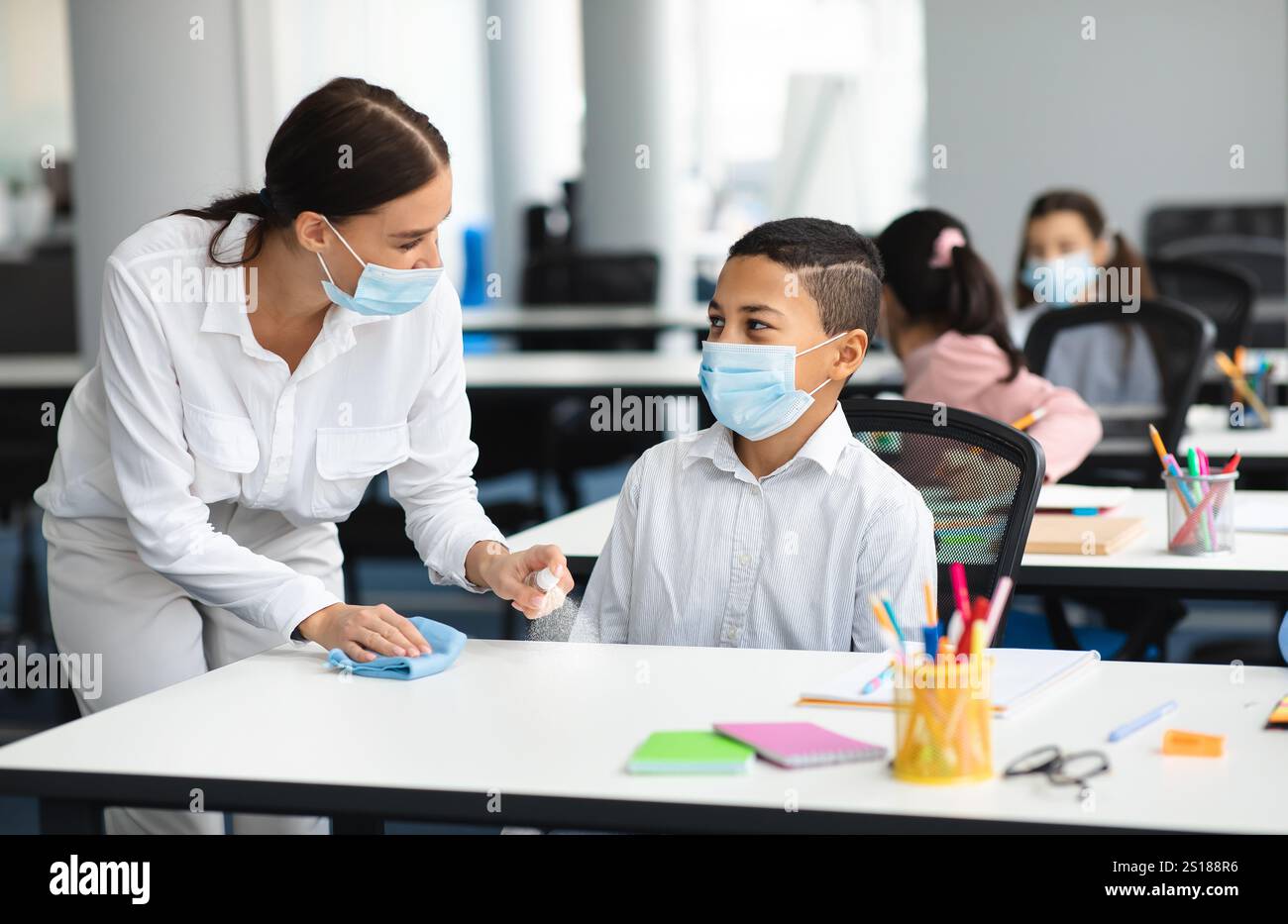 Teacher cleaning table with antibacterial sanitizer and napkin Stock ...