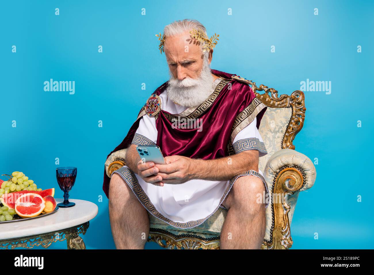 Photo of ancient philosopher sitting throne hold use smart phone ...