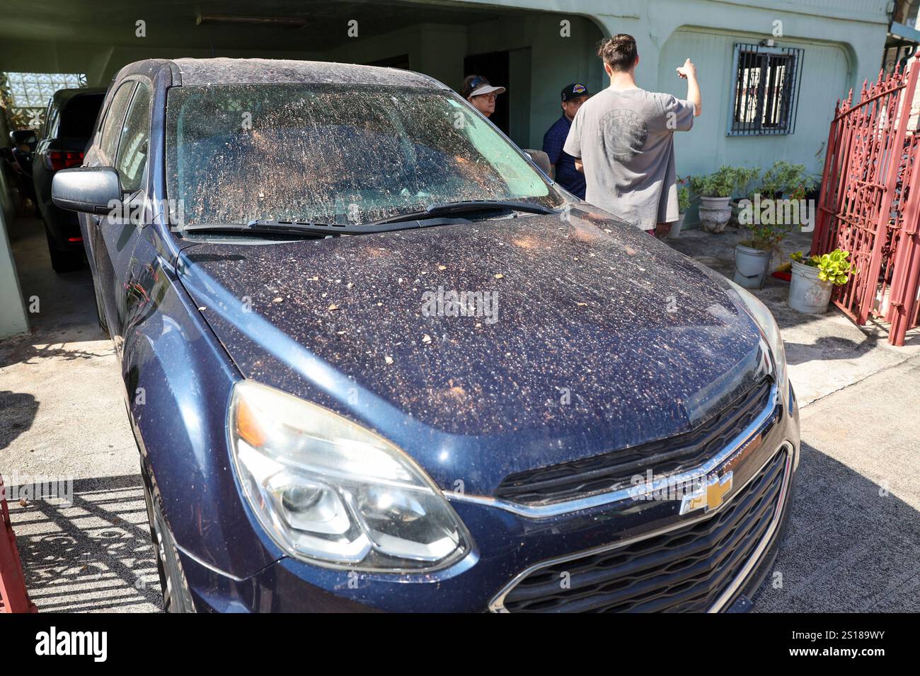 A damaged car is seen across the street from the home where a New Year ...