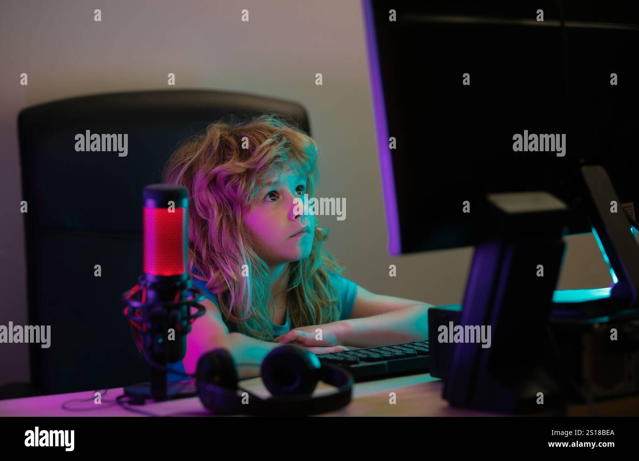 Little kid using desktop pc by night, child boy illuminated by the blue ...