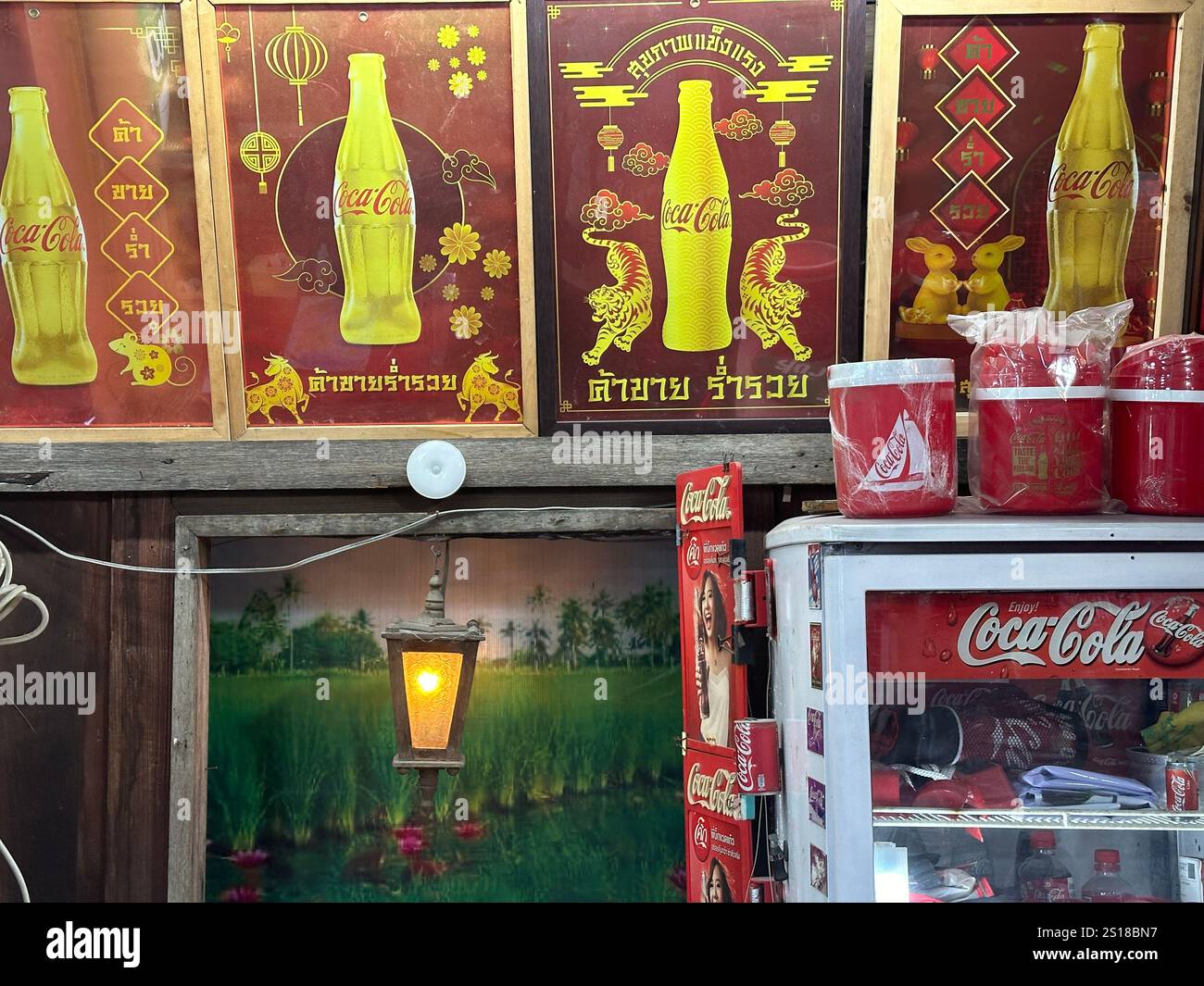 On the wall, there are numerous pictures depicting various coca cola ...