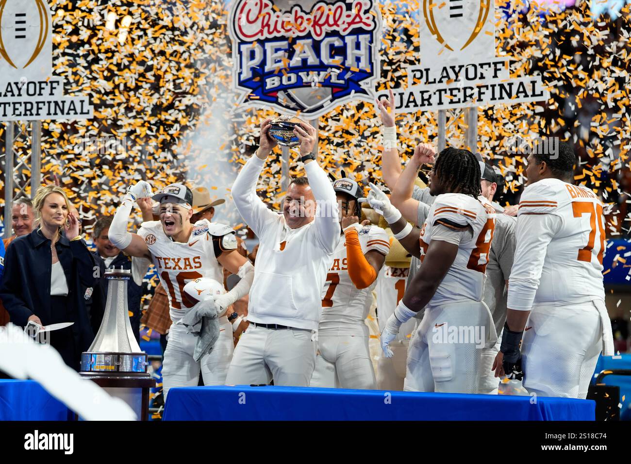 Atlanta, Georgia, USA. 1st Jan, 2025. Texas head coach Steve Sarkisian holds up the Peach Bowl ...