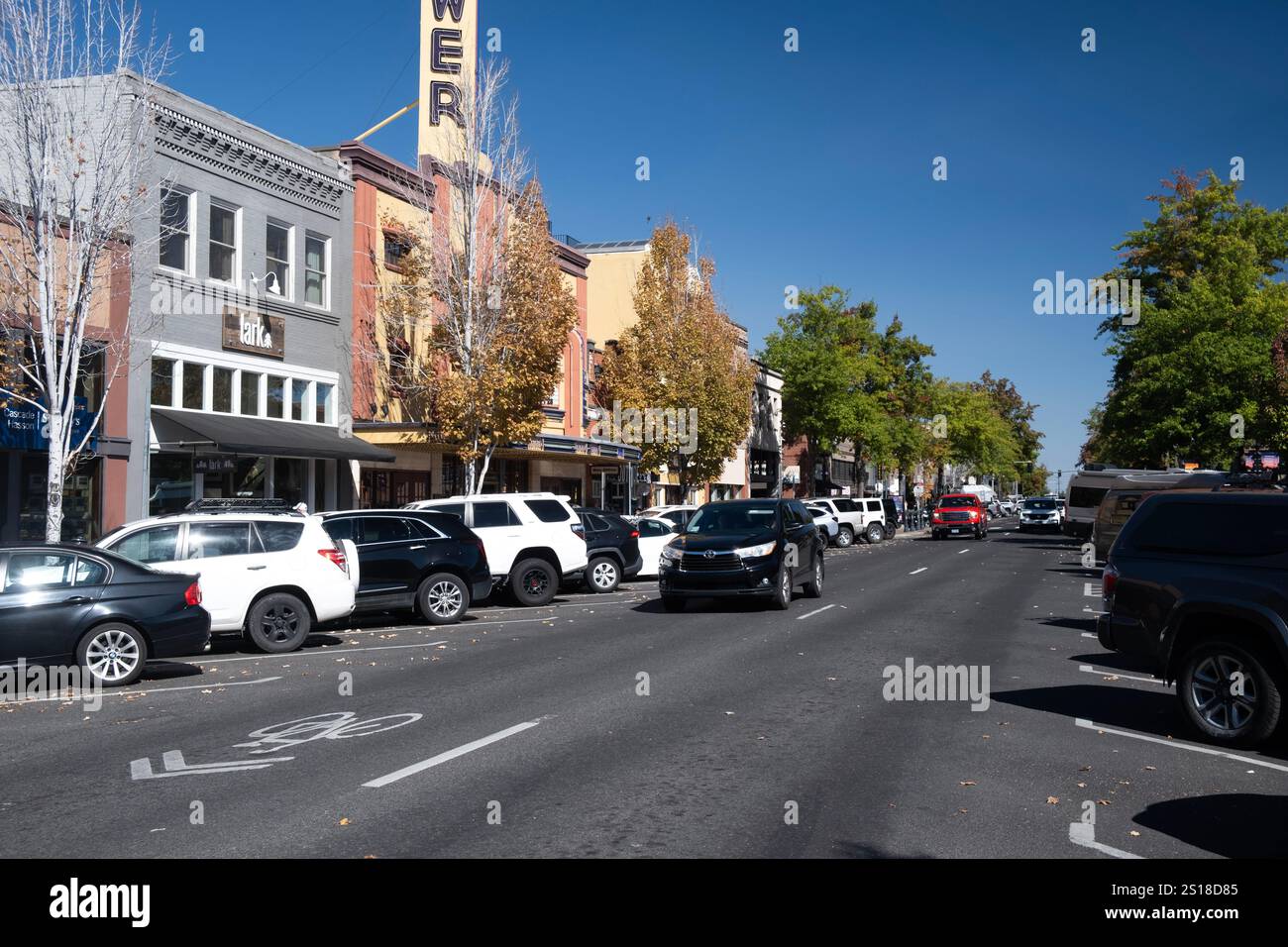 View looking up Wall Street lined with shops and restaurants in ...