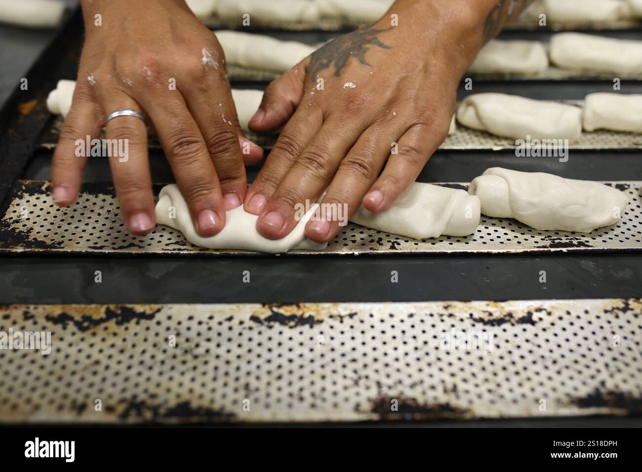 An inmate bakes bread at São João del-Rei APAC, which offers ...