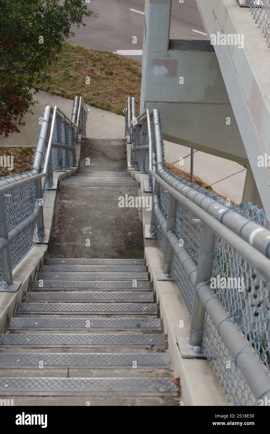 Leading lines looking down tall stairs and landing with metal railings ...