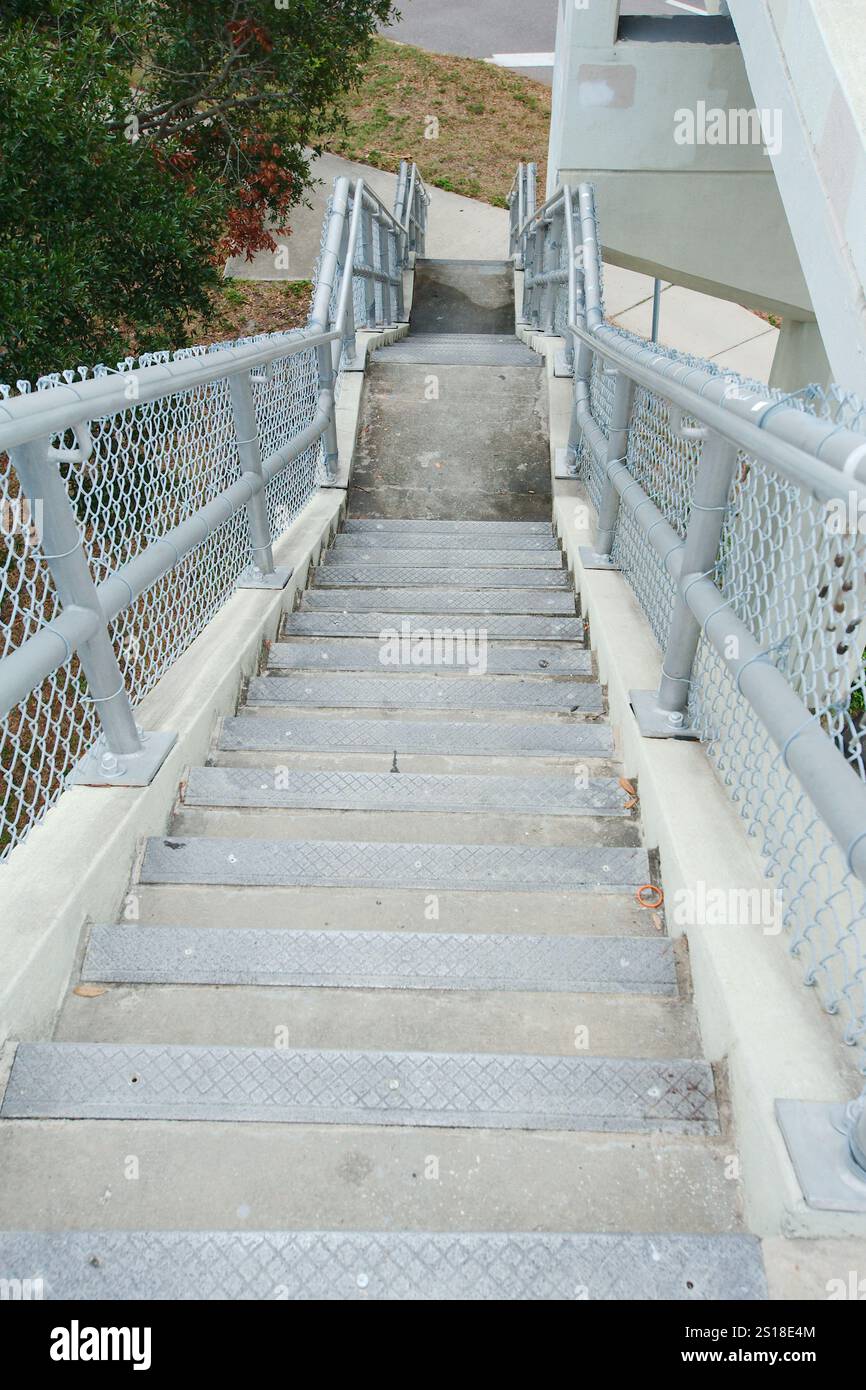 Leading lines looking down tall stairs and landing with metal railings ...