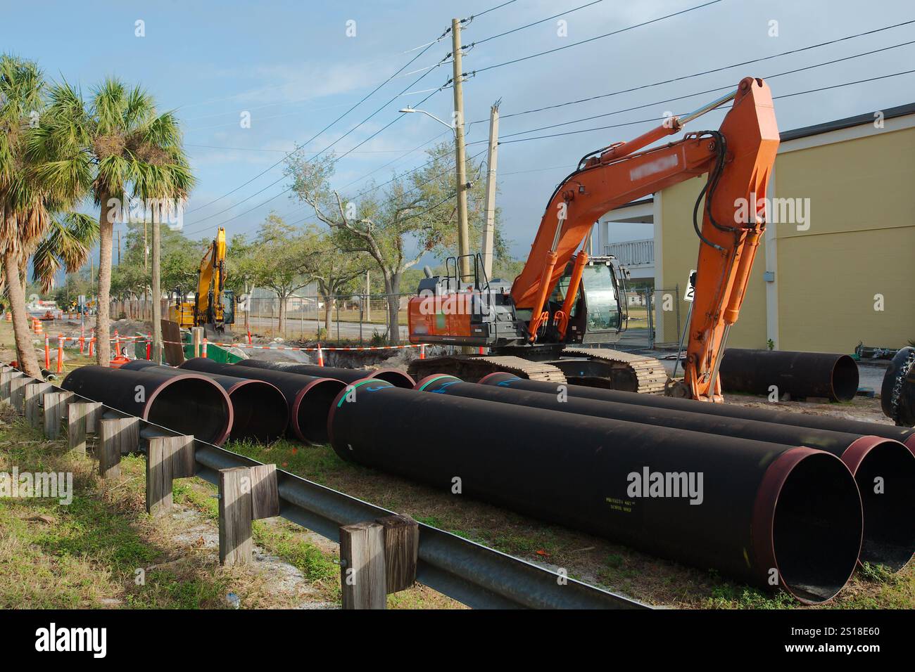 Wide view over black Raw Water Transmission Main Pipes laying on side ...