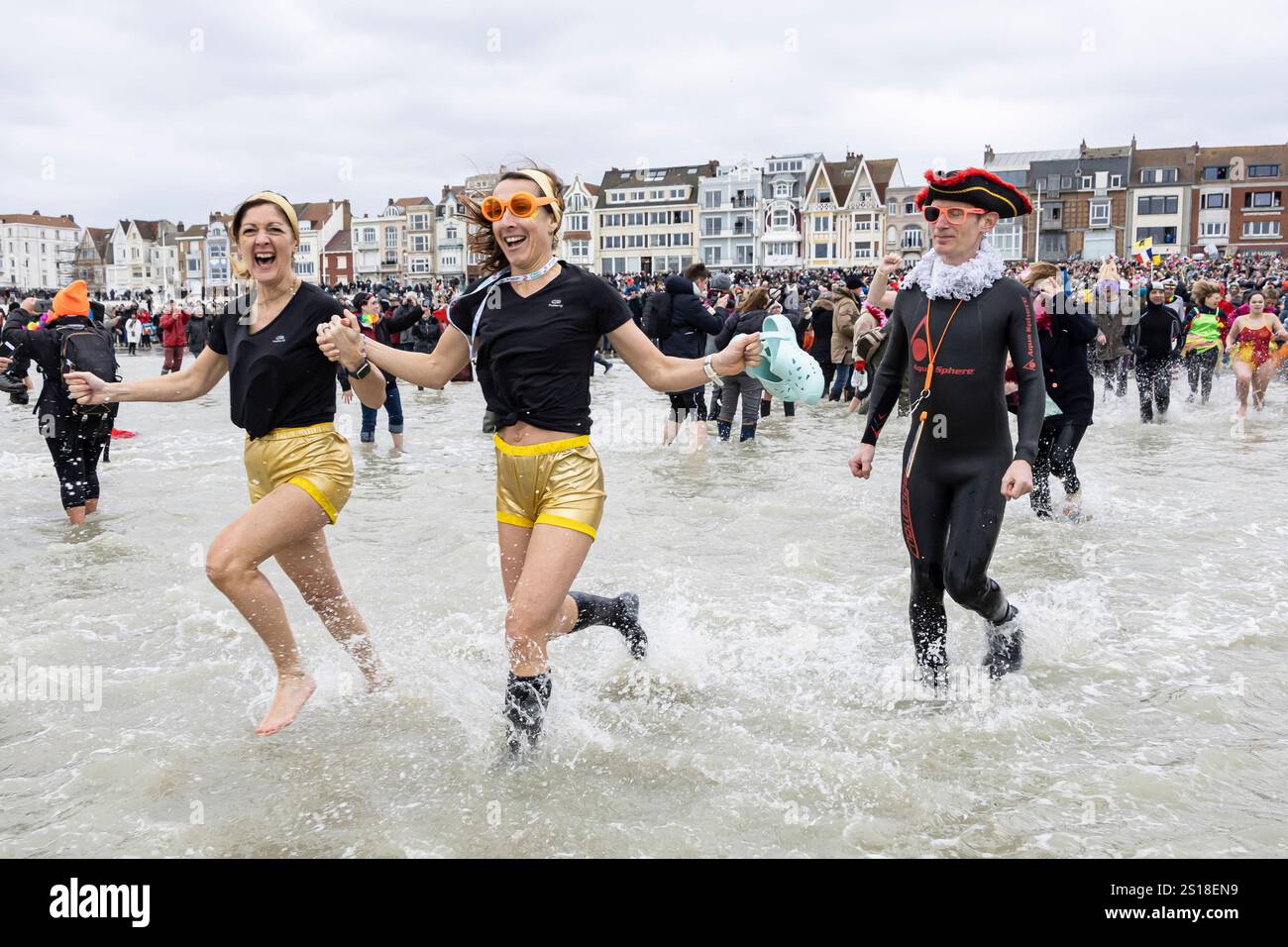 Dunkirk, France. 1st Jan, 2025. Dressed-up people run towards the sea ...