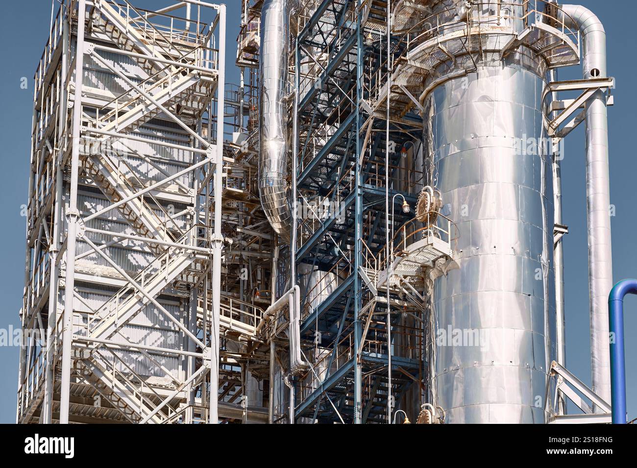 Industrial chemical plant towers with intricate piping and metallic ...