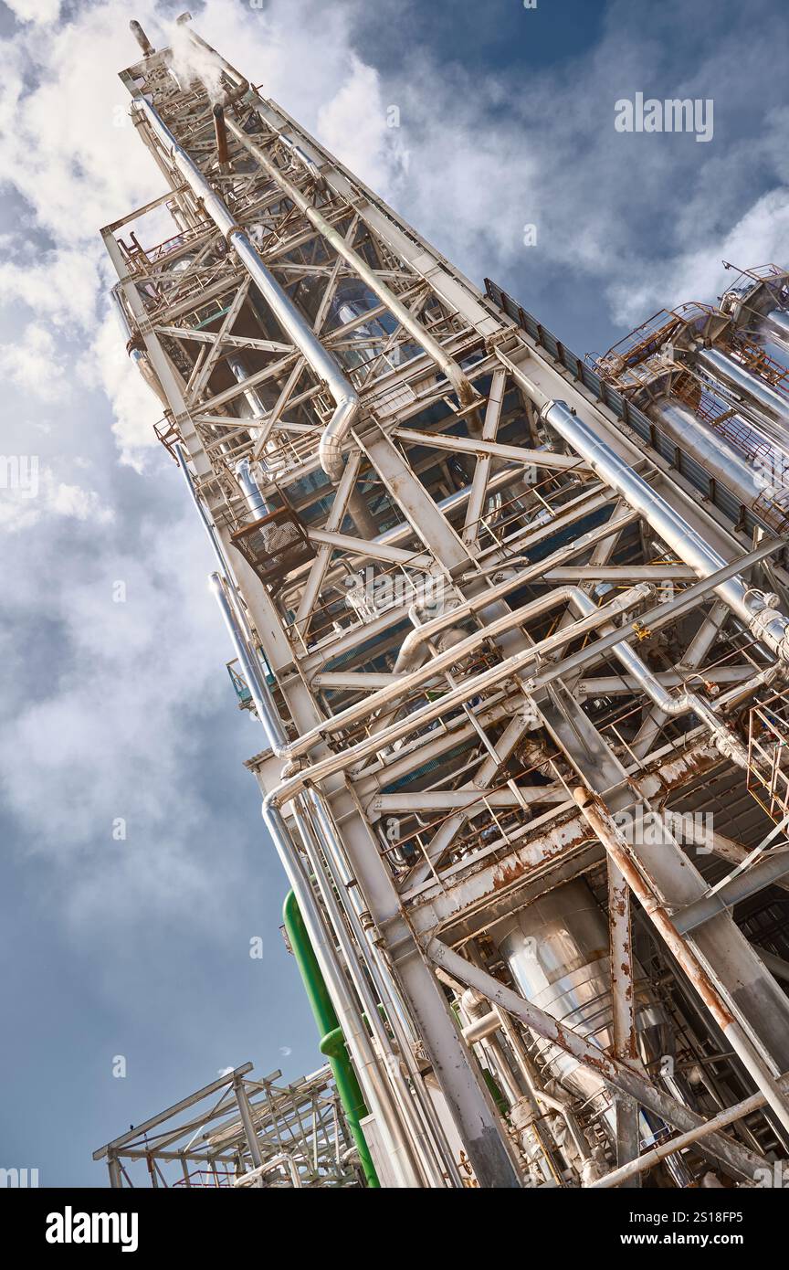 A towering structure of a chemical plant under a bright sky showcasing industrial processes and ...