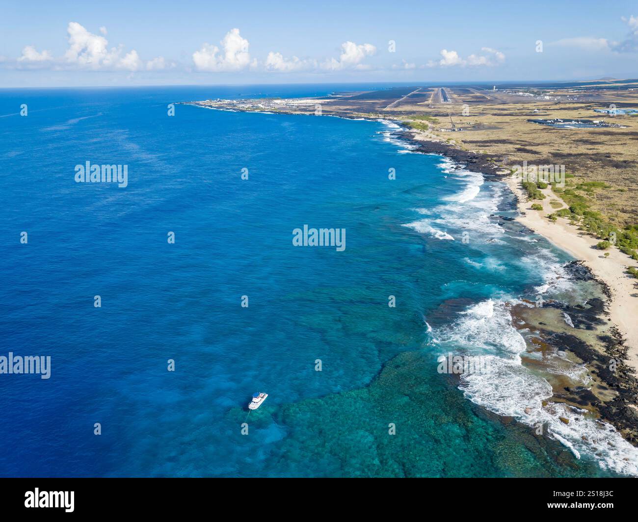 An aerial view of a boat anchored off Kohanaiki Beach with Kalihi Point ...