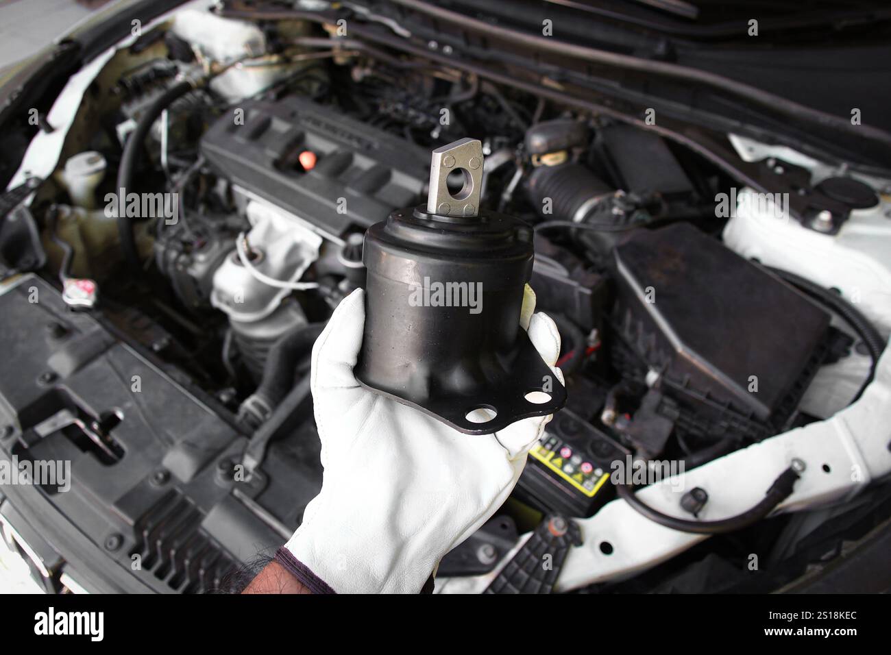 Engine mount component held in auto mechanic hand , Automotive parts ...