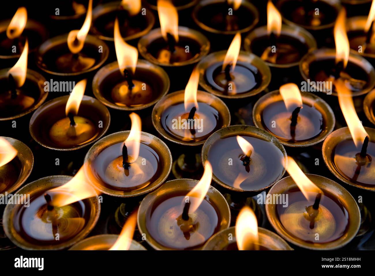 Oil lamps in a temple. In Buddhism the lighting of a candle or an oil ...