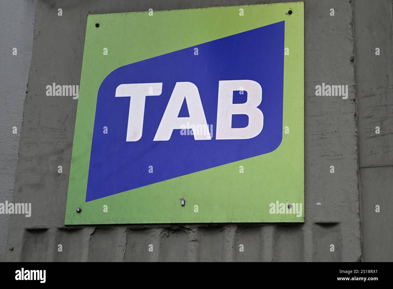 Square green and blue TAB sign on the external wall of a pub Stock ...