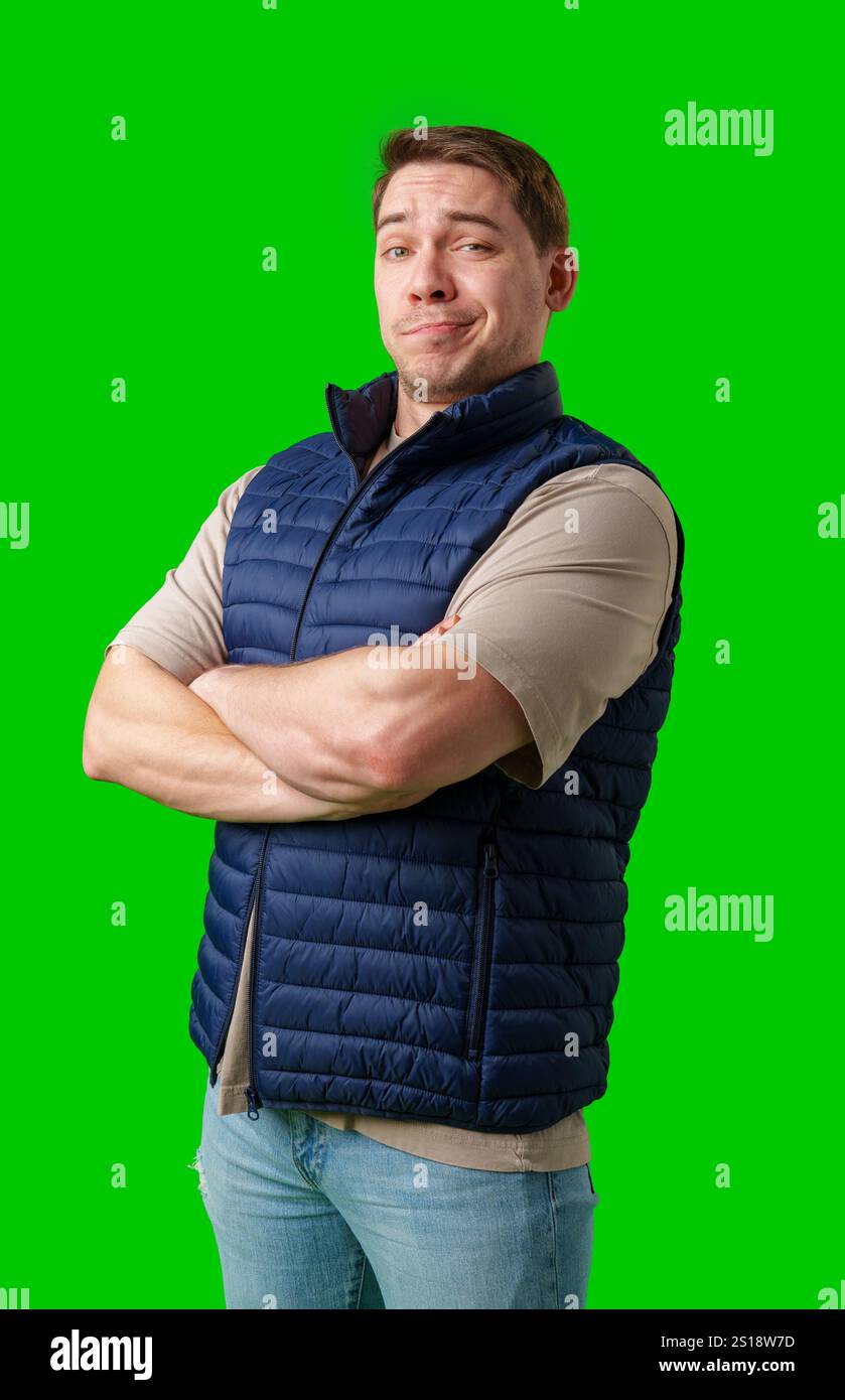 Confident man in a navy vest and t-shirt poses with crossed arms ...