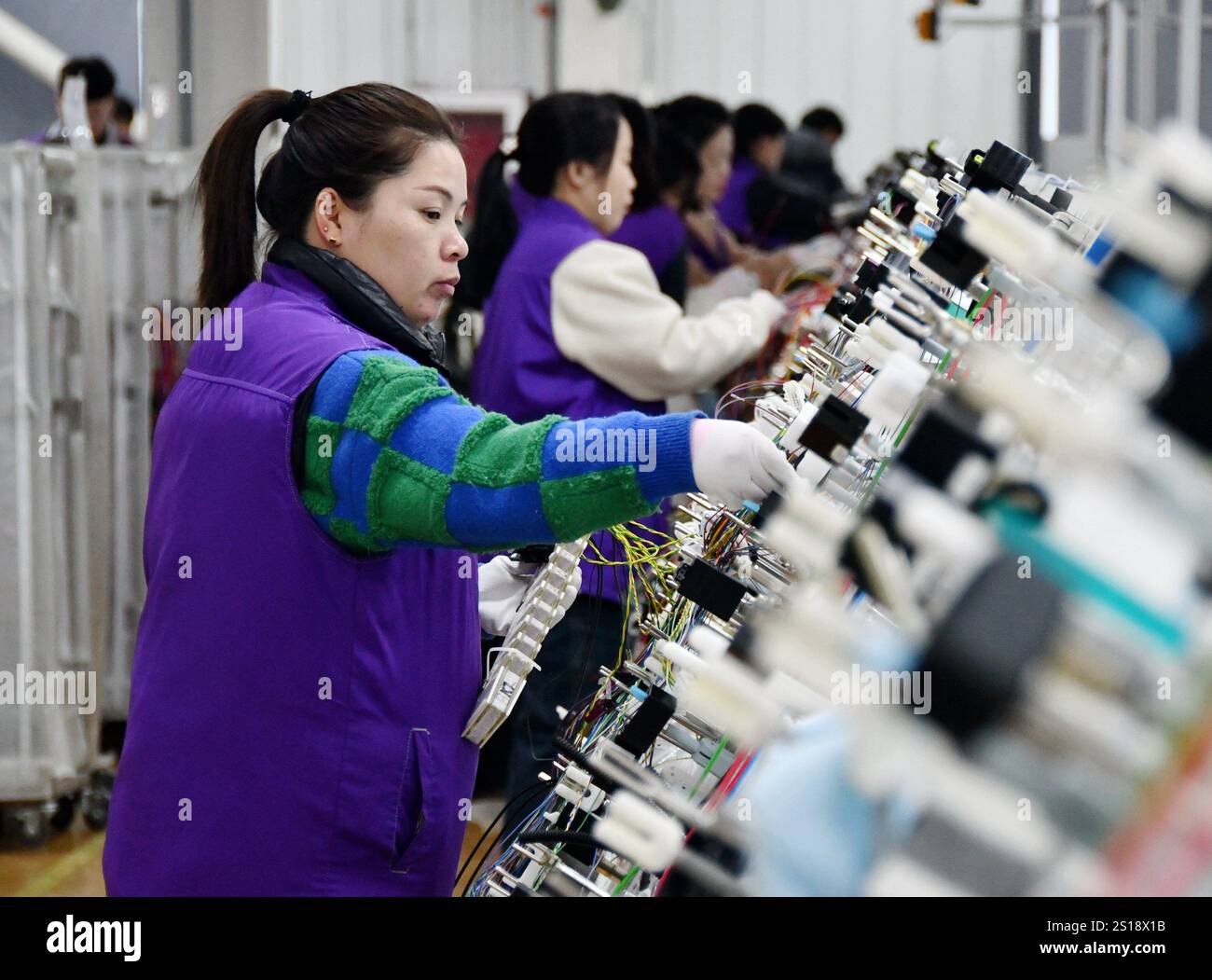 HANDAN, CHINA - JANUARY 2, 2025 - Workers work on a car harness ...