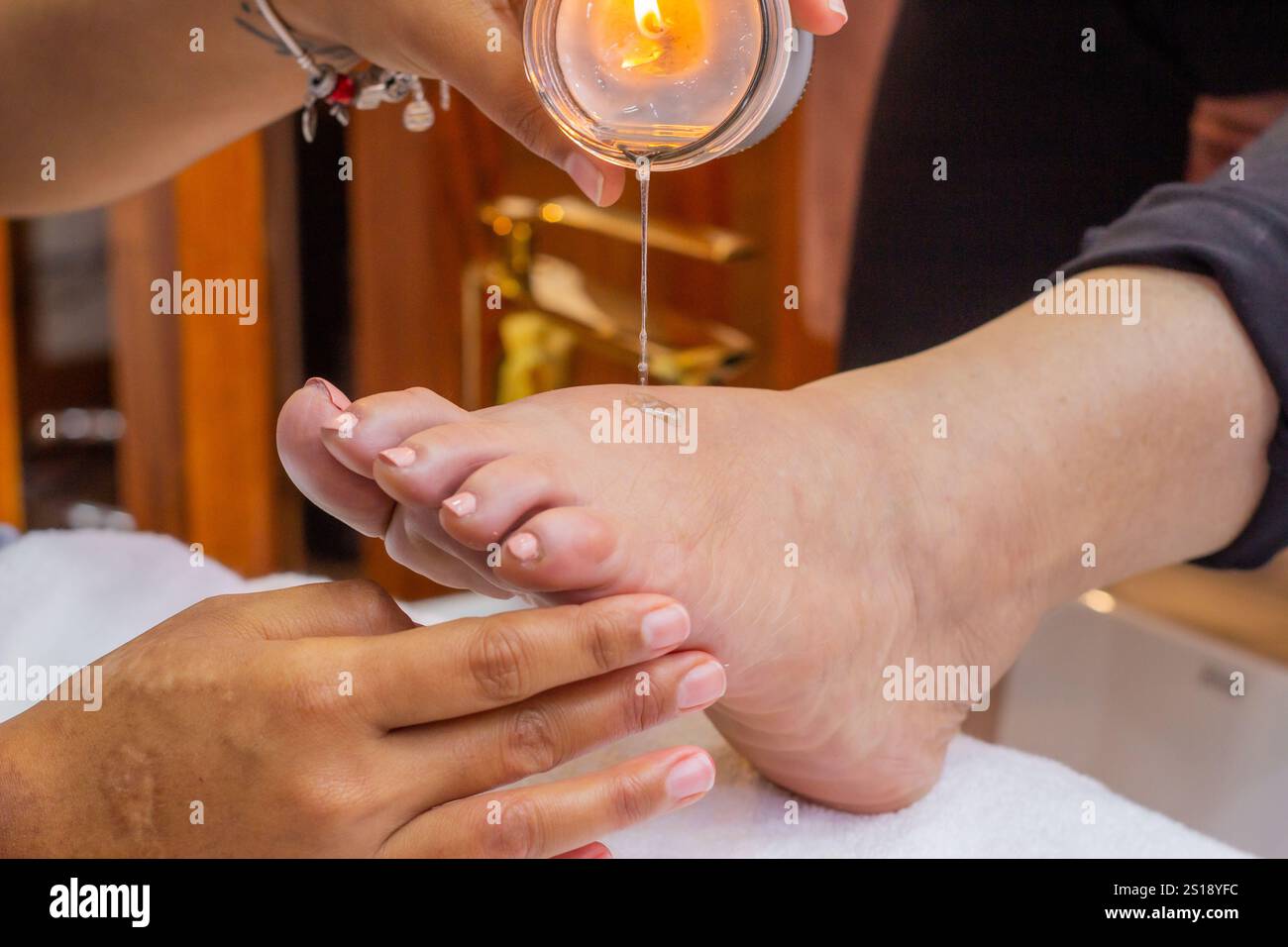 foot care treatment with hot candle, salon spa Stock Photo - Alamy