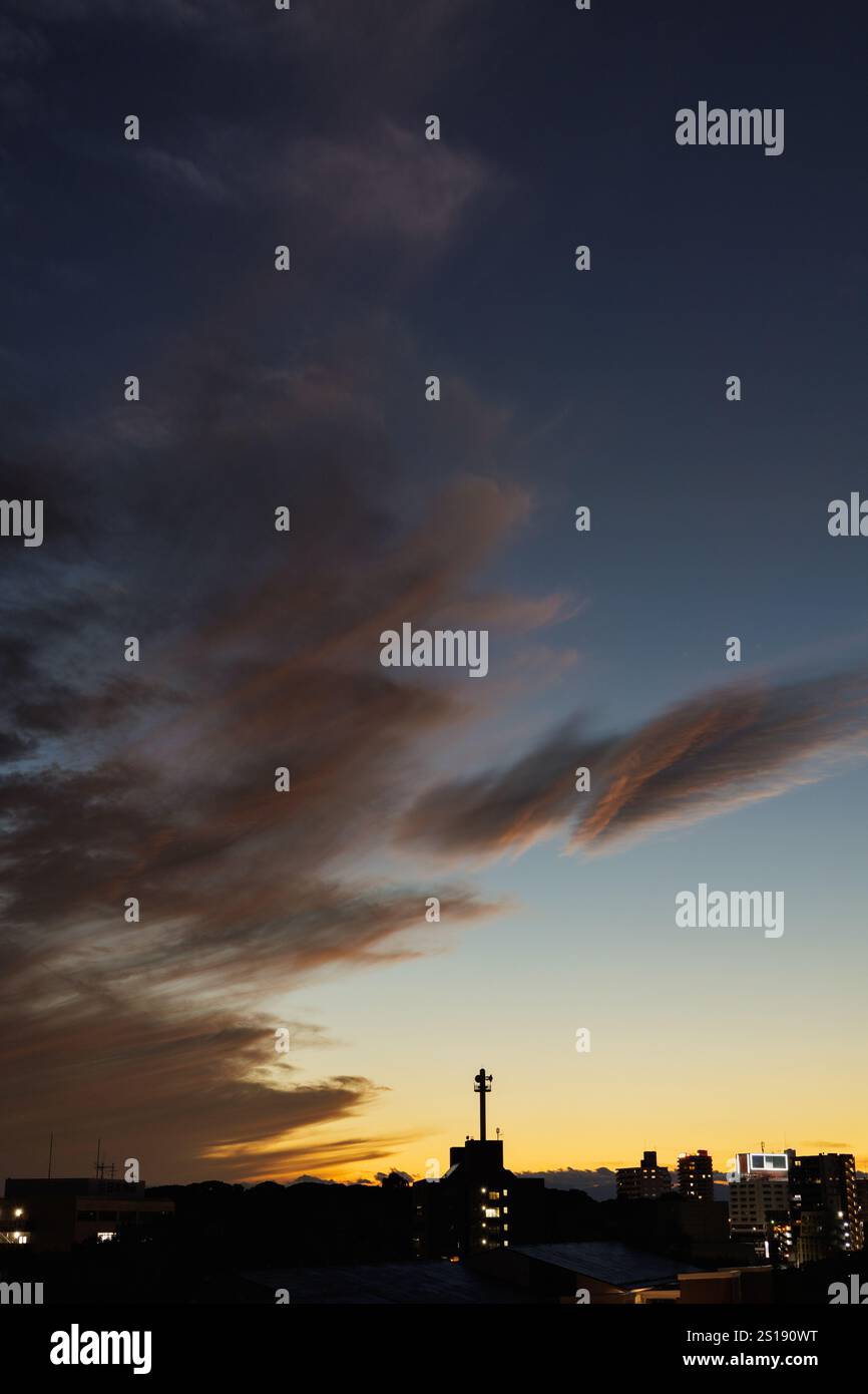 Light streaks of orange string across vertically stacked wispy clouds ...