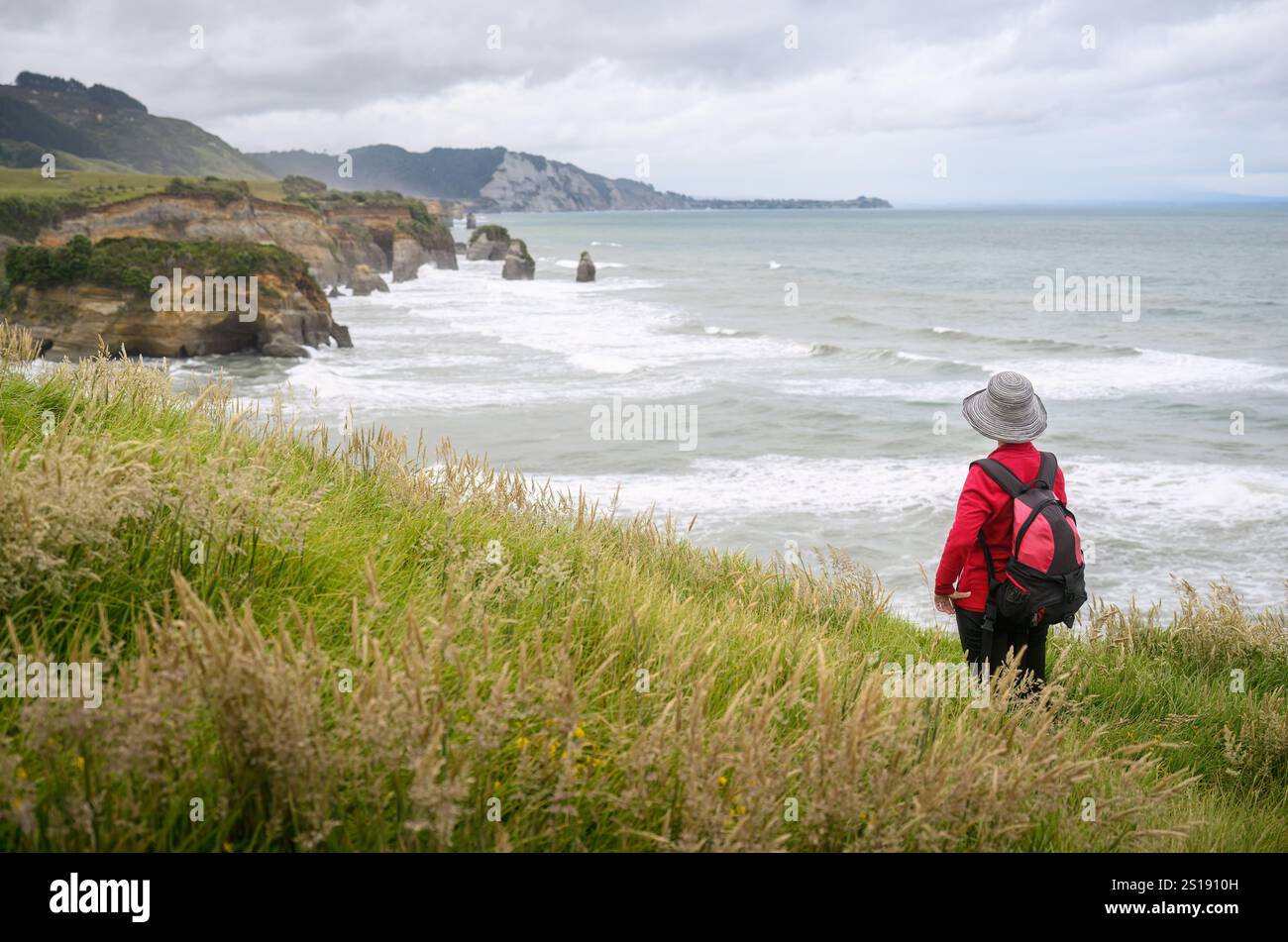 Woman looking at the view of Three Sisters rock formation. Tongaporutu ...