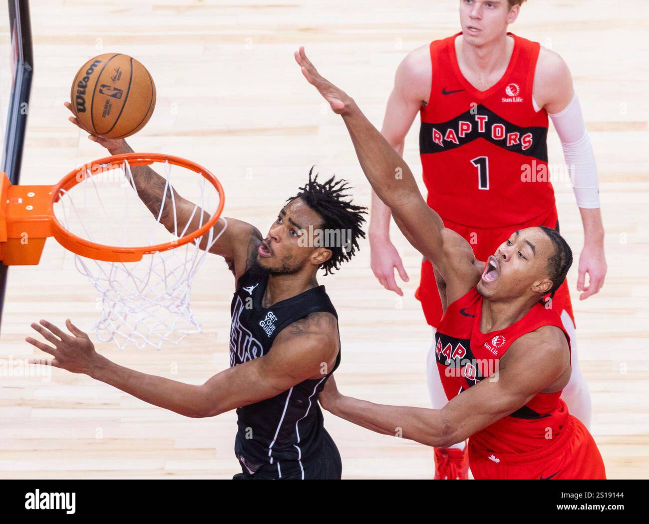 Toronto, Canada. 1st Jan, 2025. Nic Claxton (L) of Brooklyn Nets goes ...