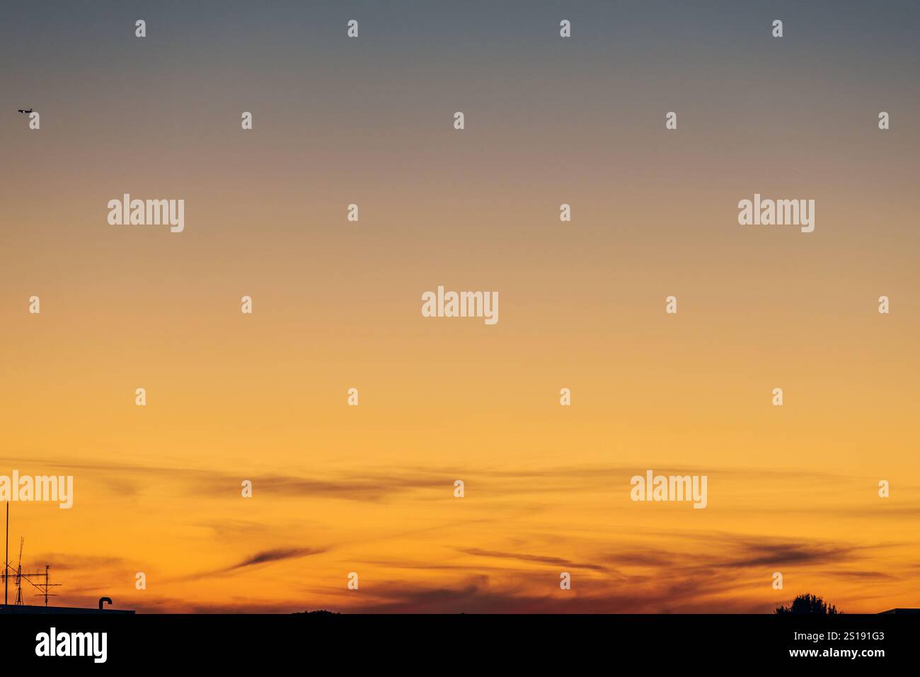 Wispy clouds swirl at the bottom of a sunset sky in transition from ...