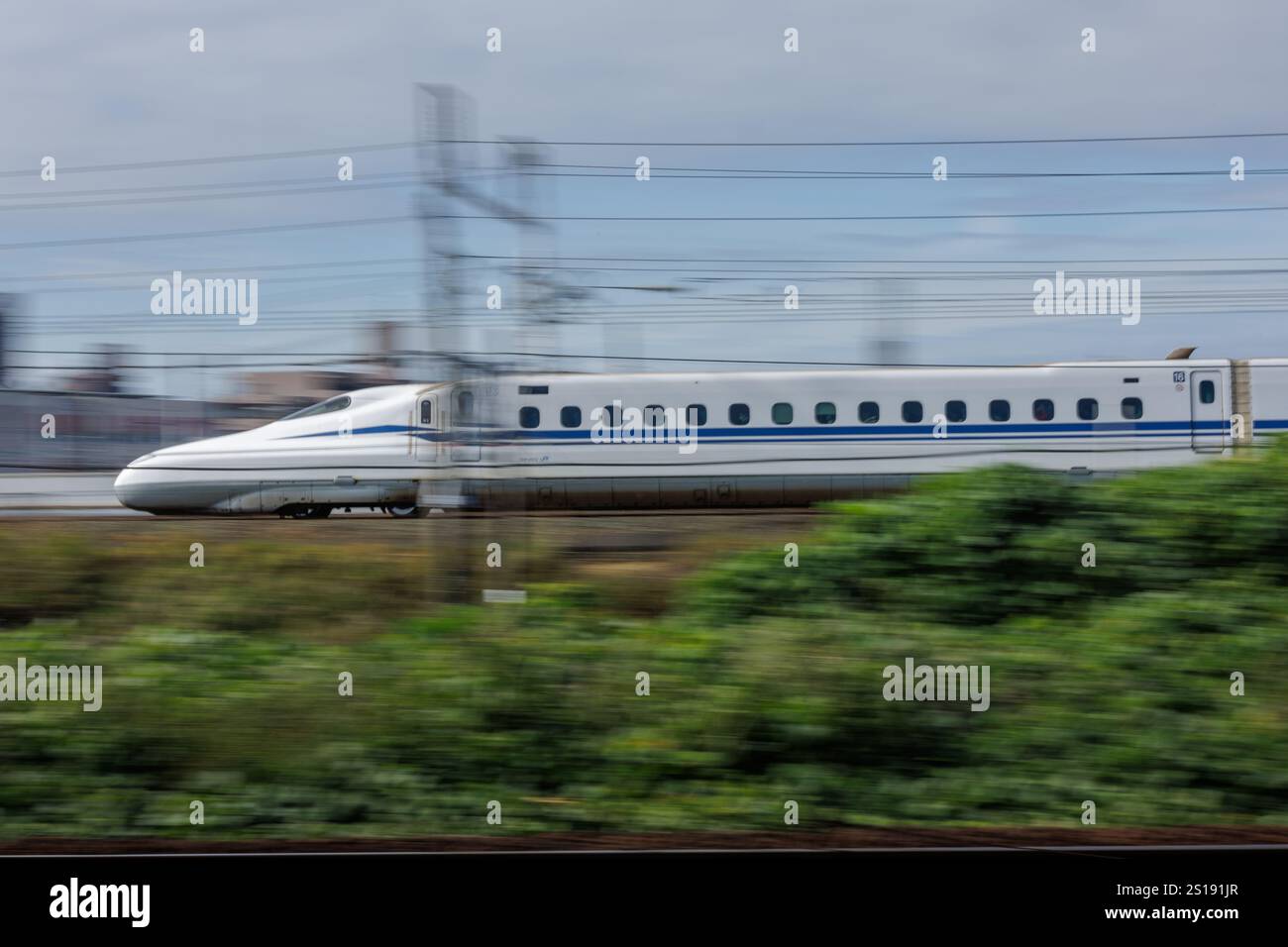Japan's Nozomi Shinkansen departs Nagoya Station. Photographed in motion blur to emphasize speed ...