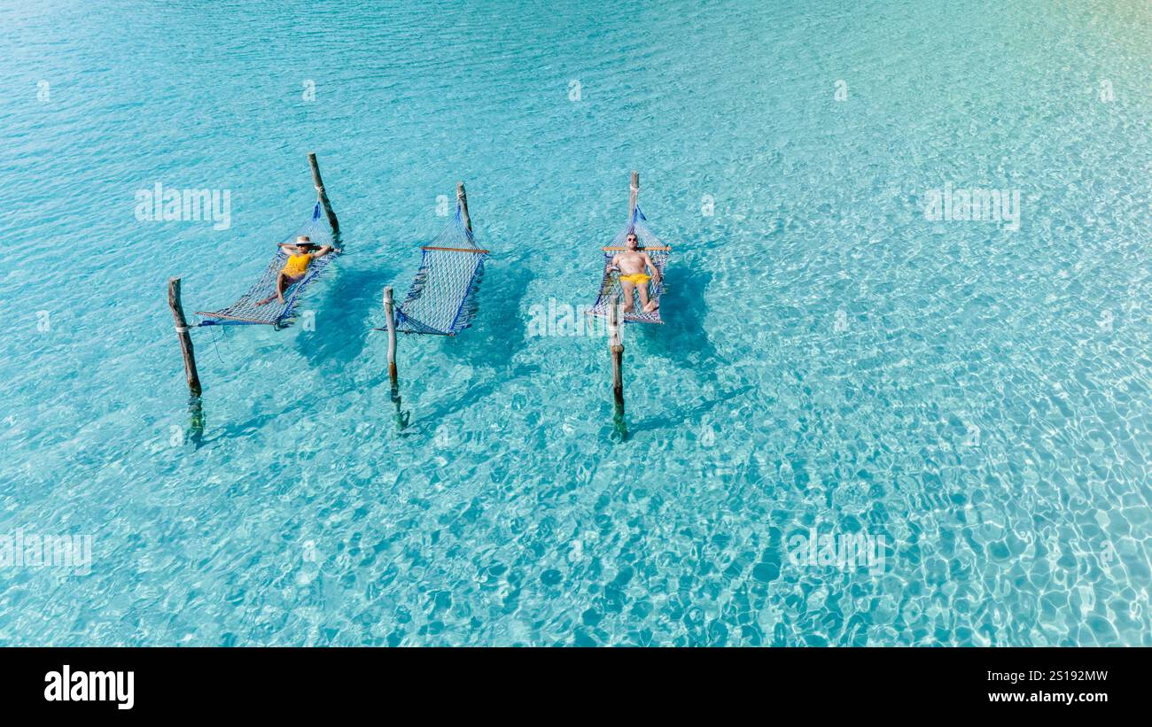 Sunbathers lounge on floating hammocks hi-res stock photography and ...
