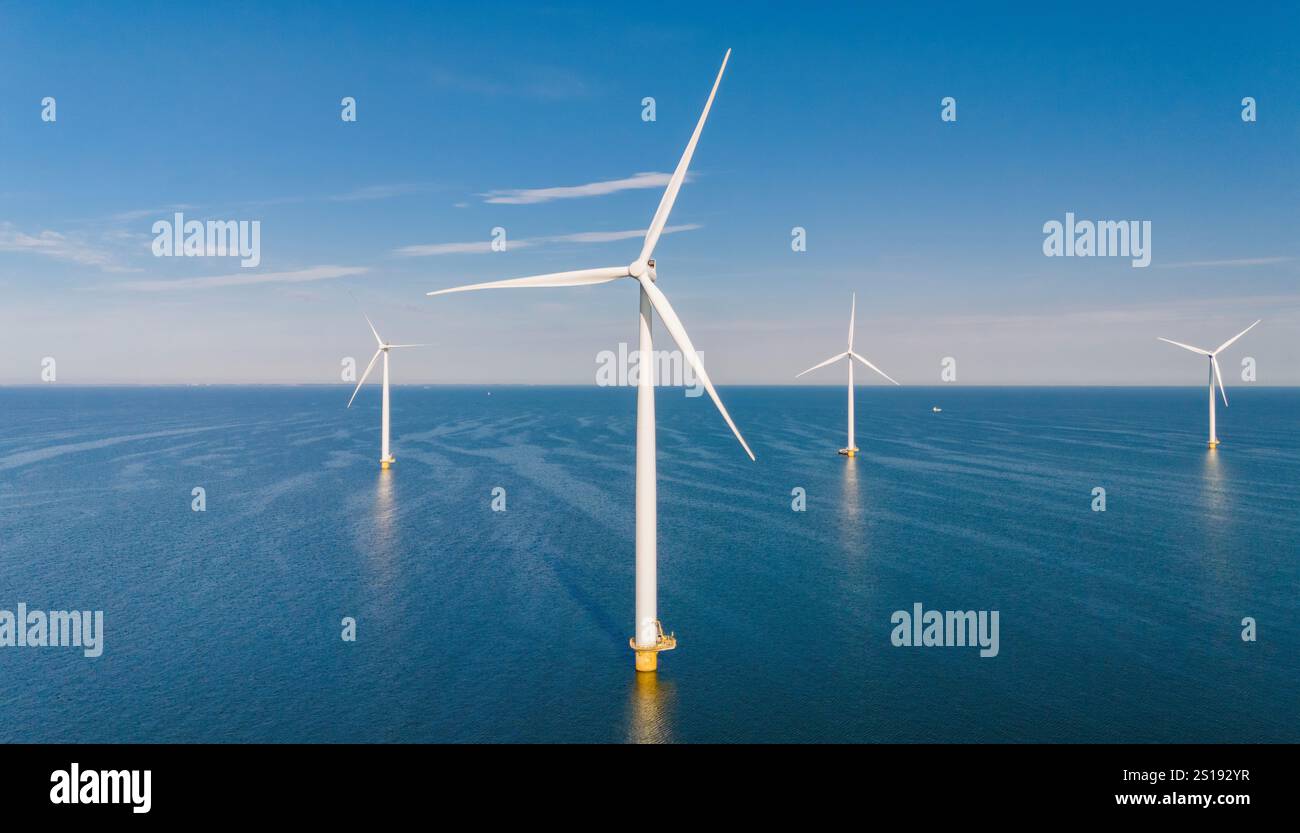 Tall wind turbines stand majestically above calm waters, converting ...