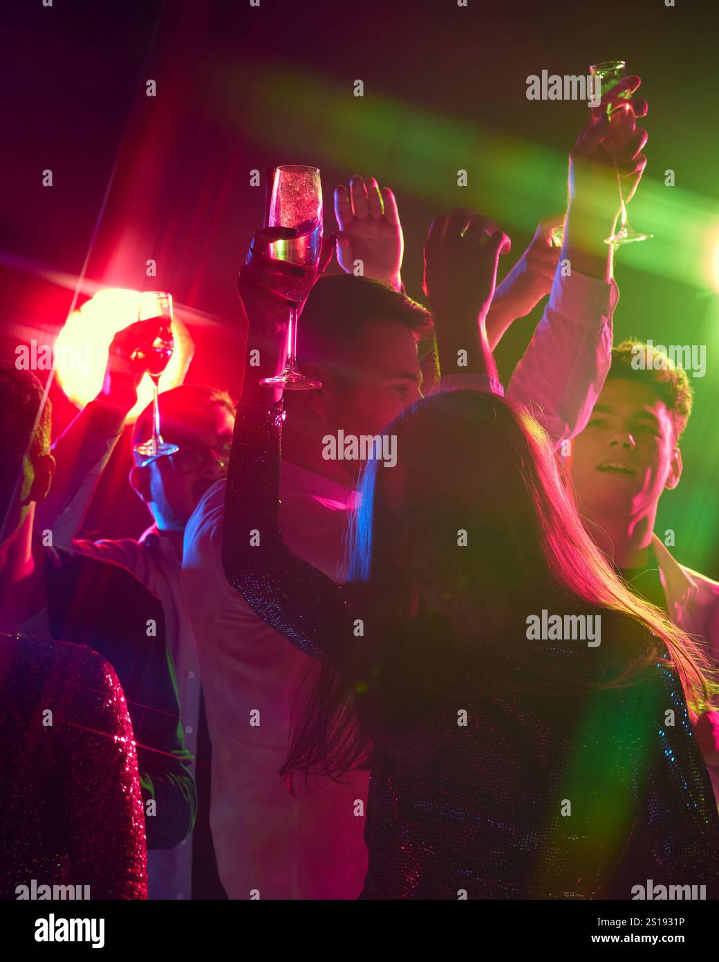 Happy birthday celebration. Champagne glasses shimmer as crowd dances ...