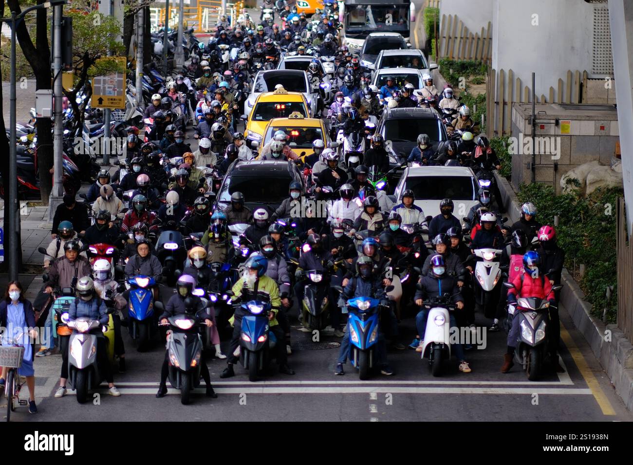 Several early morning commuters on motorbikes stop at the intersection ...