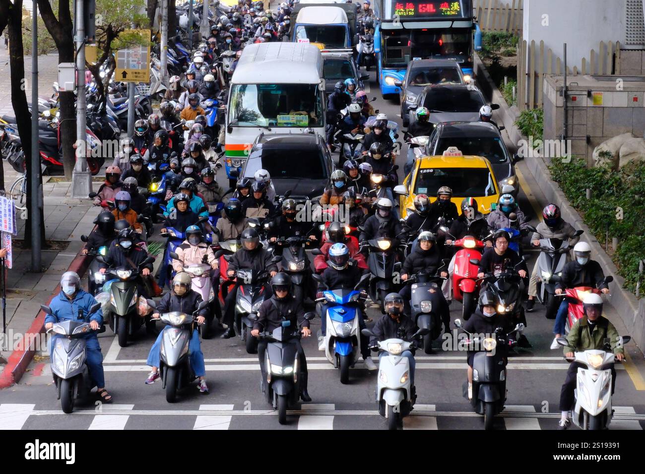 Several early morning commuters on motorbikes stop at the intersection ...