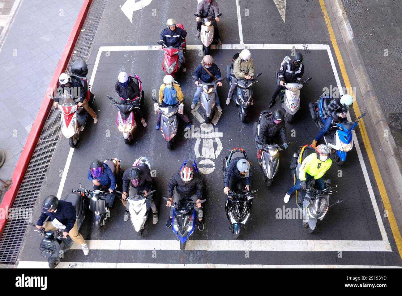 Several early morning commuters on motorbikes stop at the intersection ...