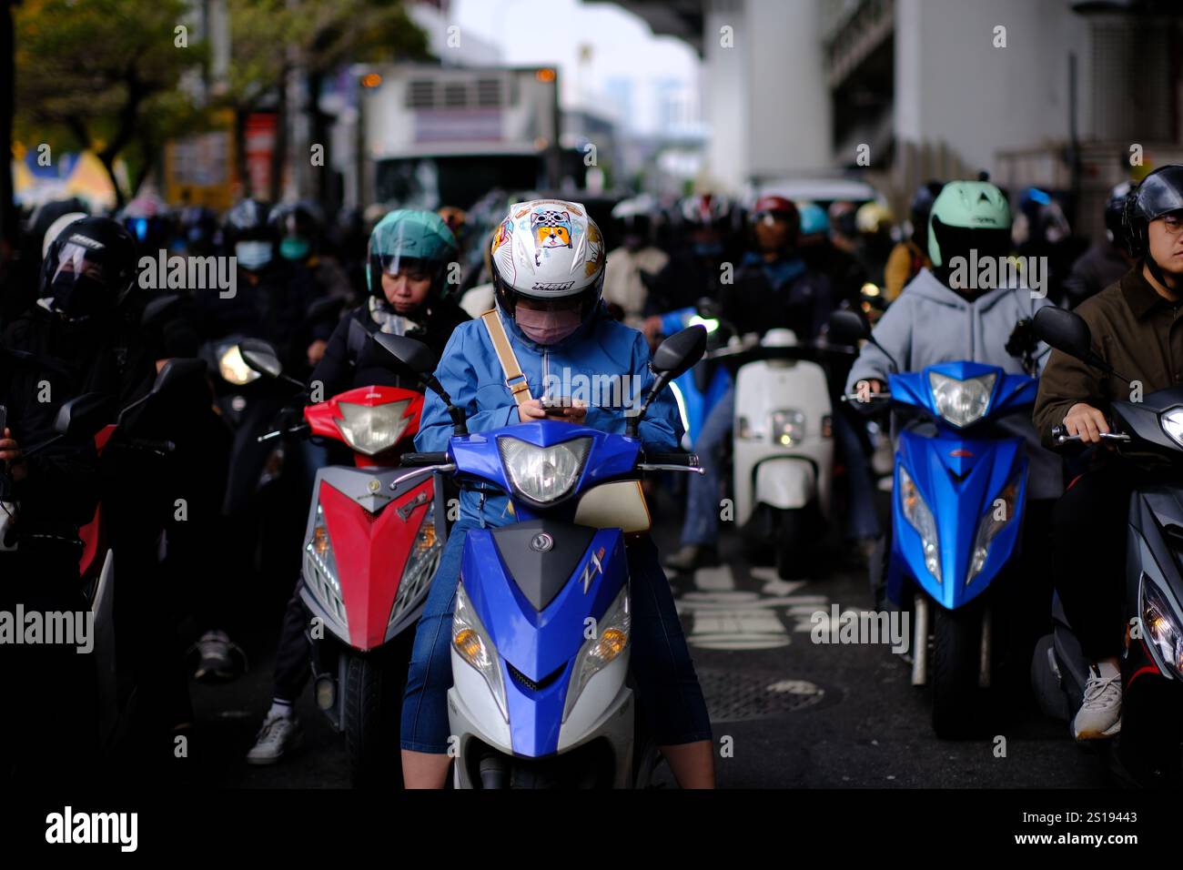 Several early morning commuters on motorbikes stop at the intersection ...