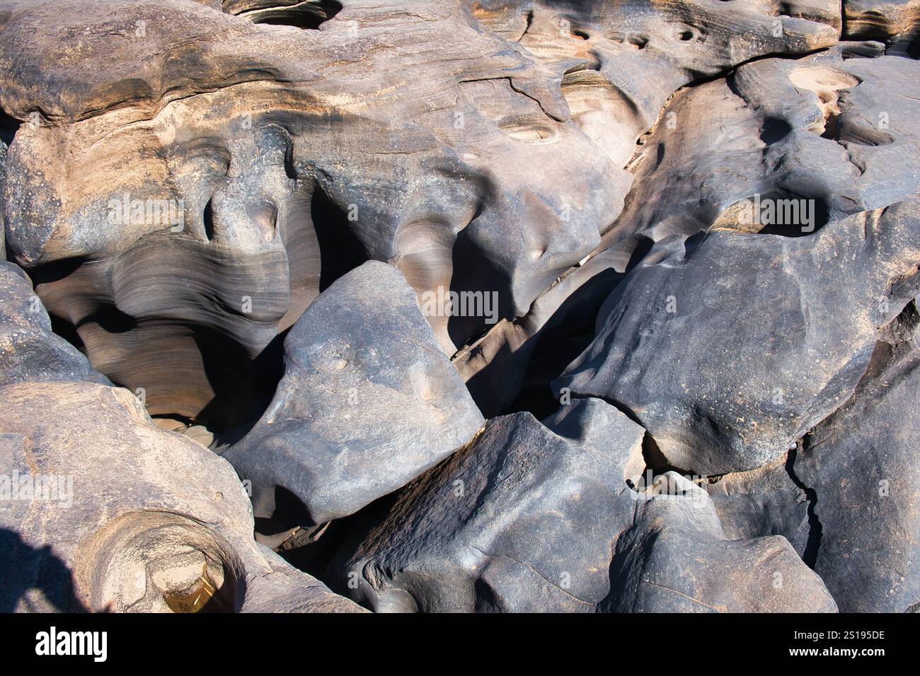 Natural potholes eroded into abstract patterns in sandstone. Loei Dun ...