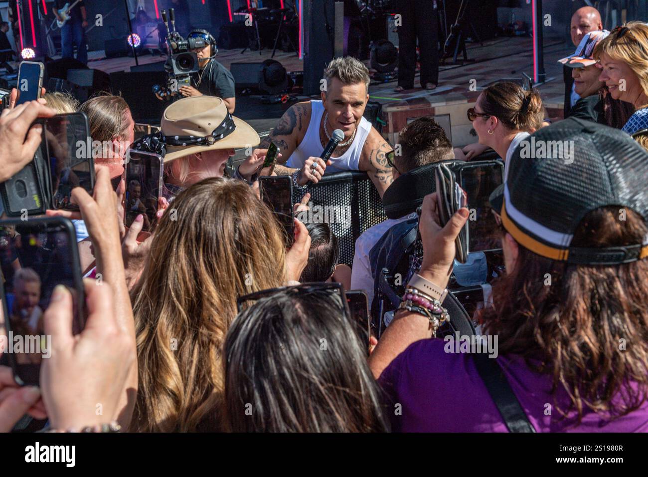 Robbie Williams get up close with the fans as he sings one of his big ...