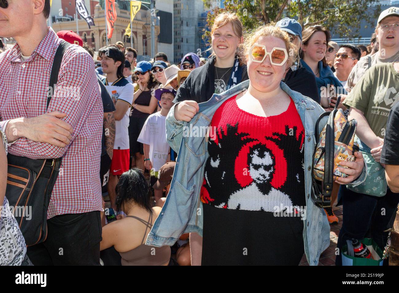 A fan with her Robbie Williams jumper waits in the sun for the singer ...