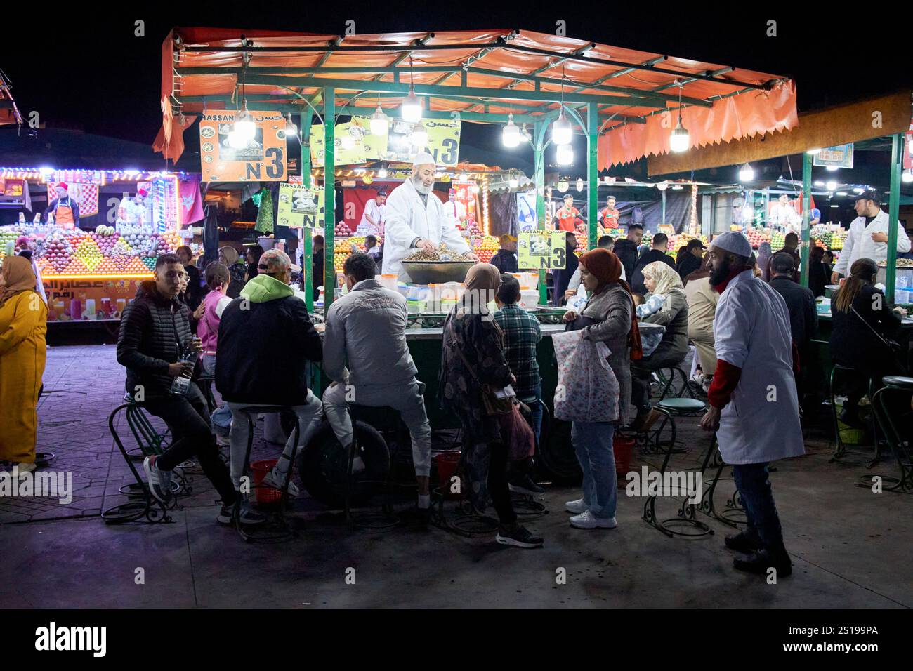 local people sitting eating snails at street food at one of the food ...