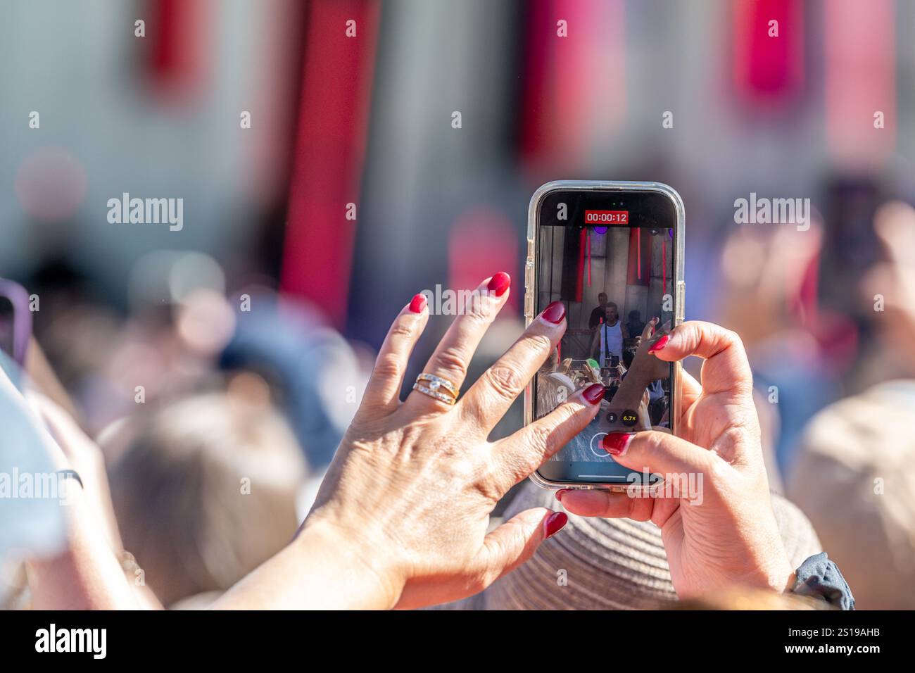 A fans captures a moment on her phone as Robbie Williams gives a free ...