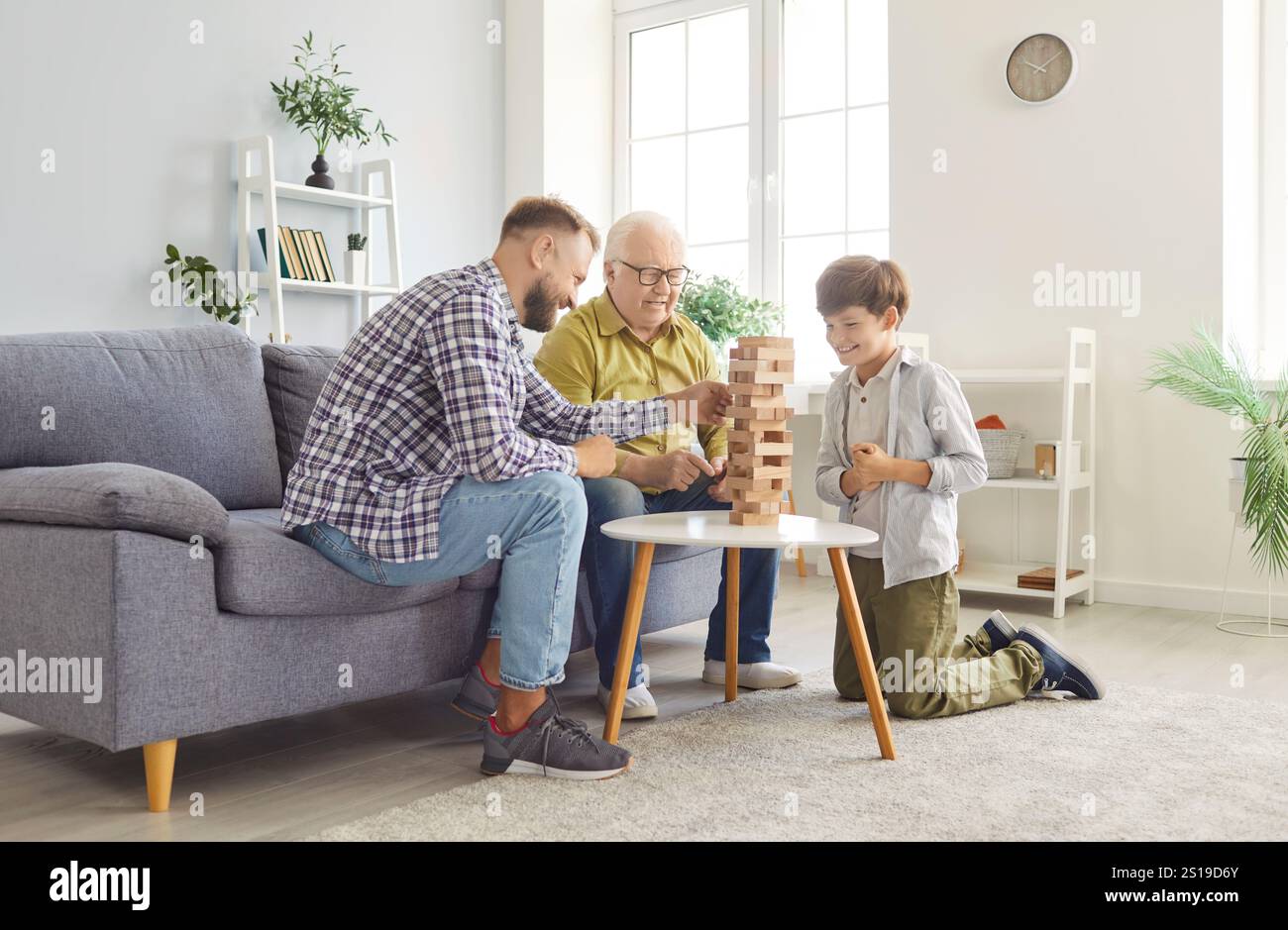Family with child boy playing an educational wooden pyramid game ...