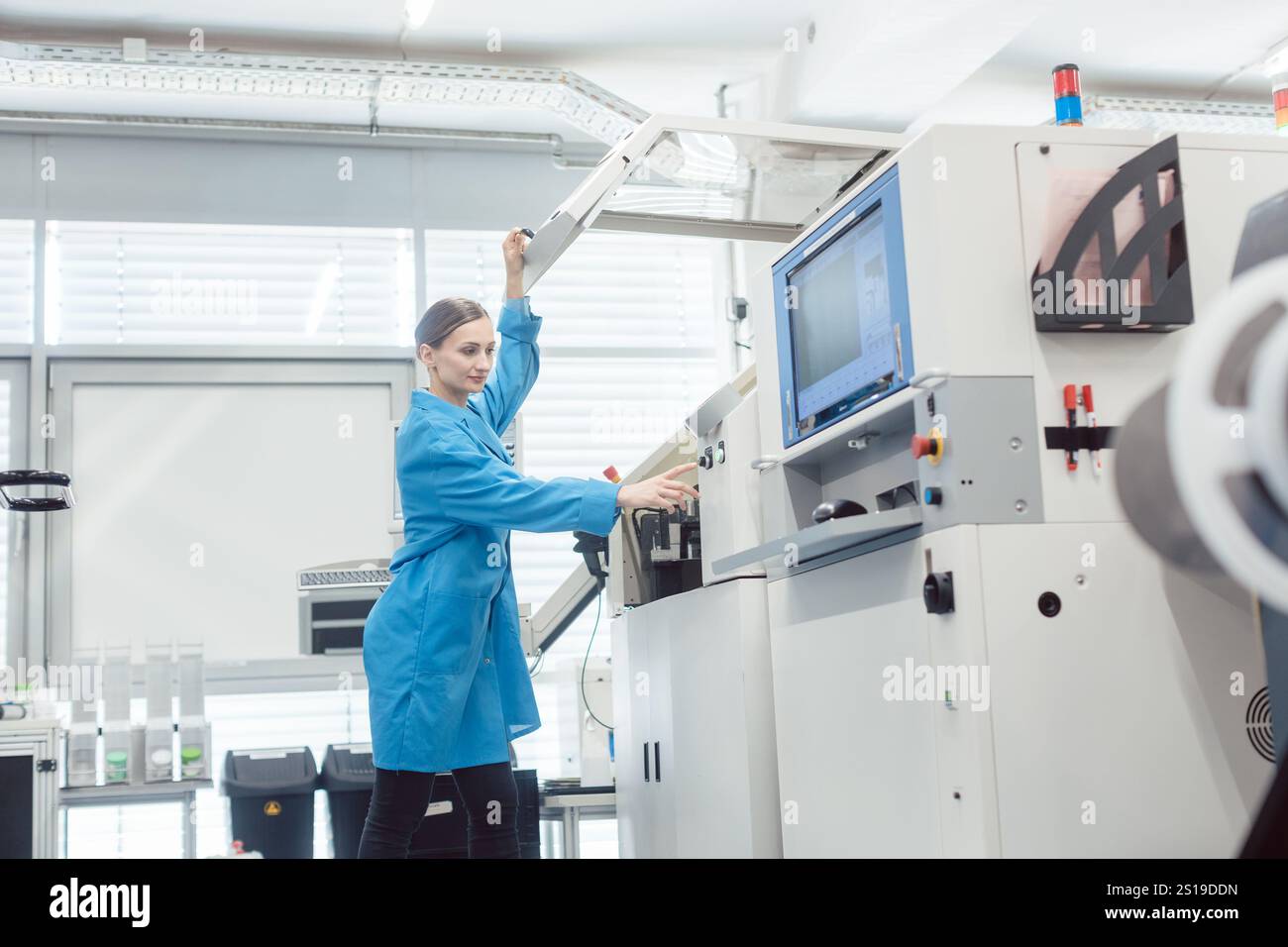 Woman worker at visual inspection of PCB on electronics assembly line ...