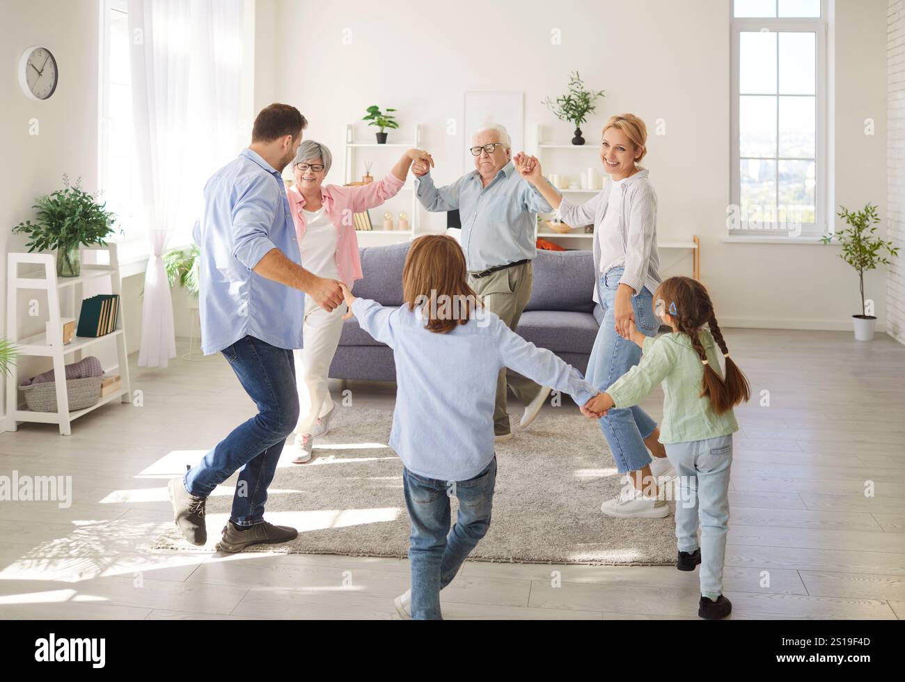 Three happy generations family common funny dance at home in new living ...