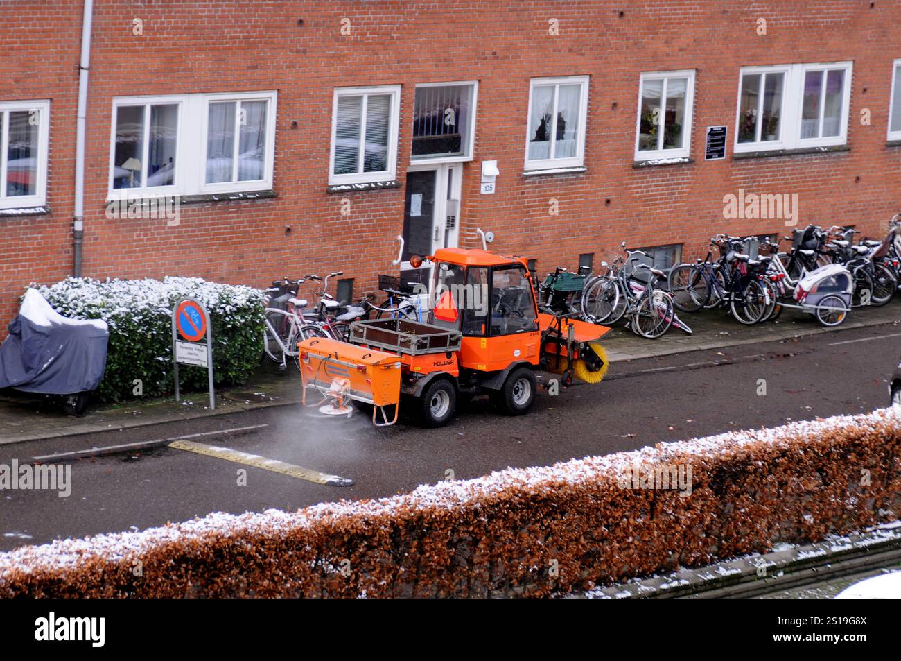 Copenhagen/ DenmarK/02 JANUARY 2025/Landlord spreading salt due to snow ...