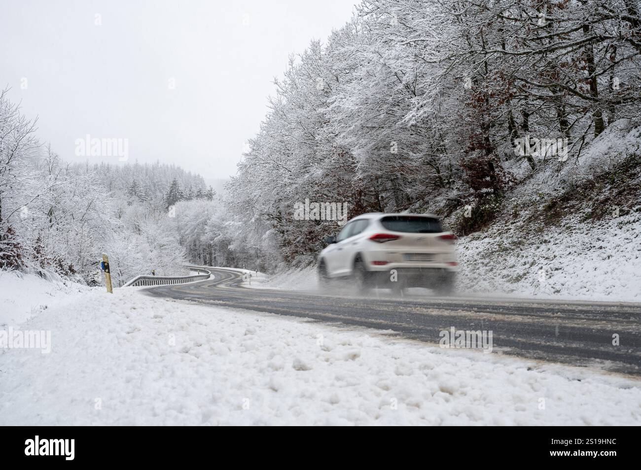 Philippsweiler, Germany. 02nd Jan, 2025. A car drives on the L9 through the snow-covered ...